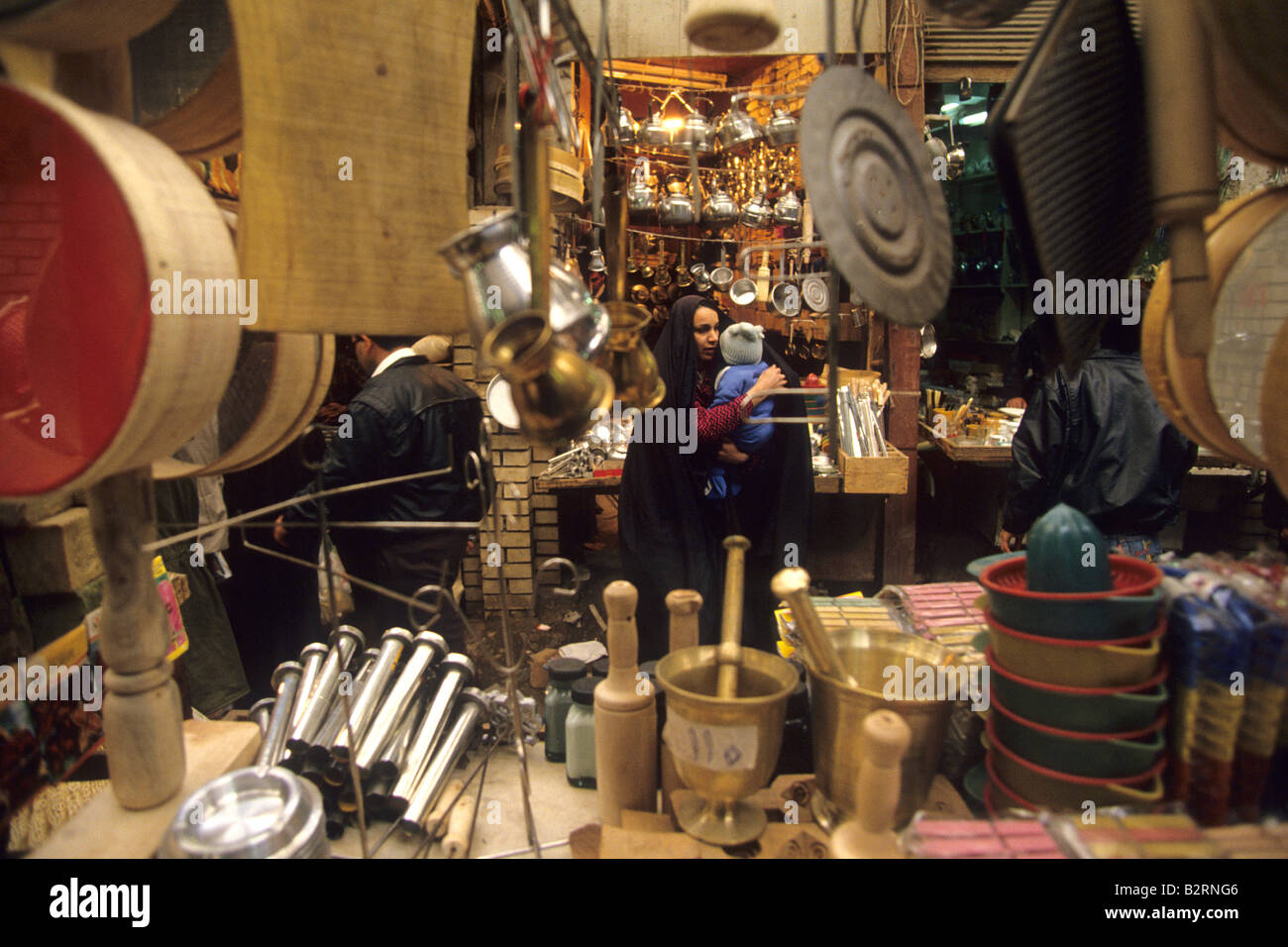 Shoppers look at household products displayed at a market stall in ...