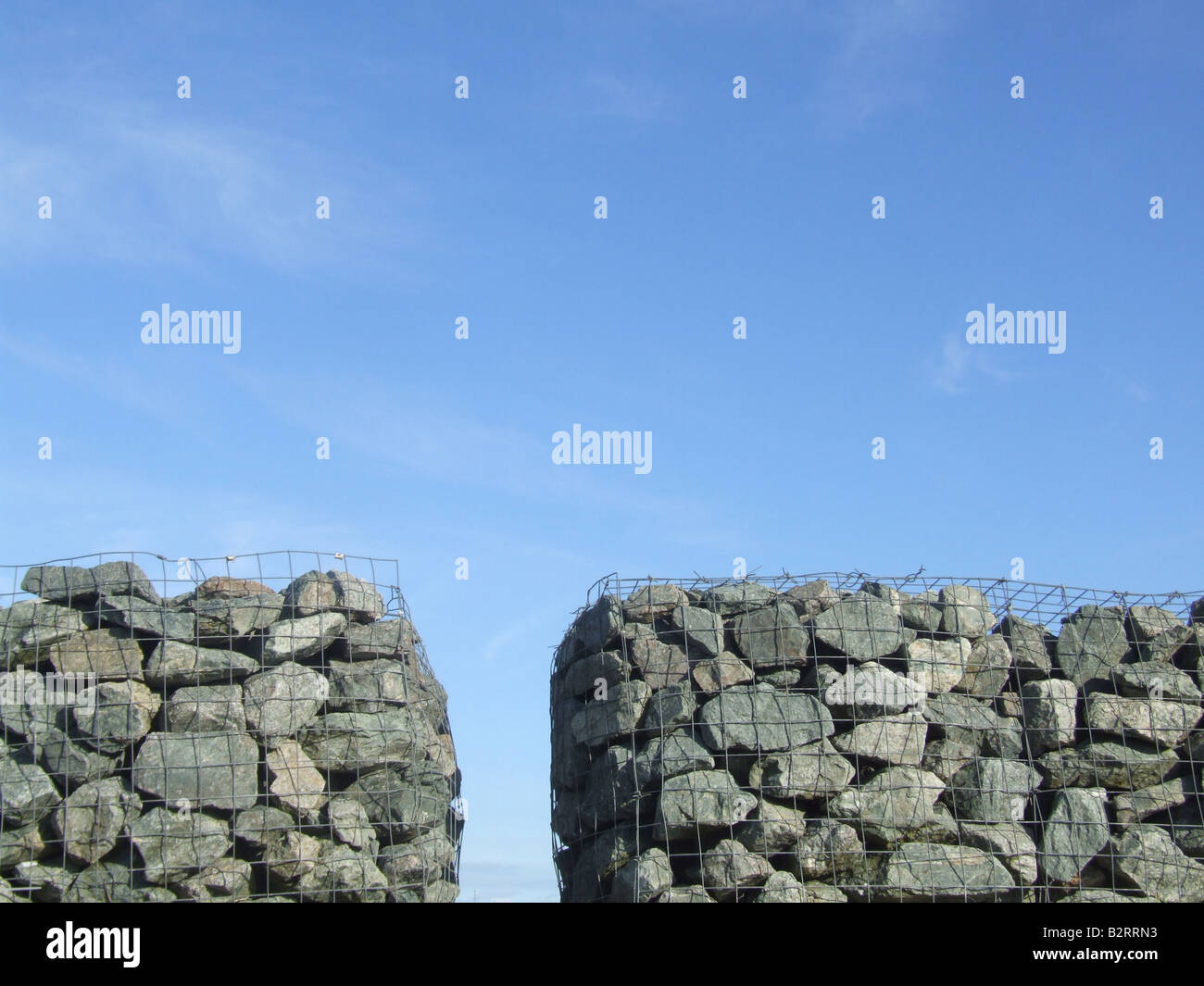 pile of rocks supported in a steel wire mesh Stock Photo - Alamy