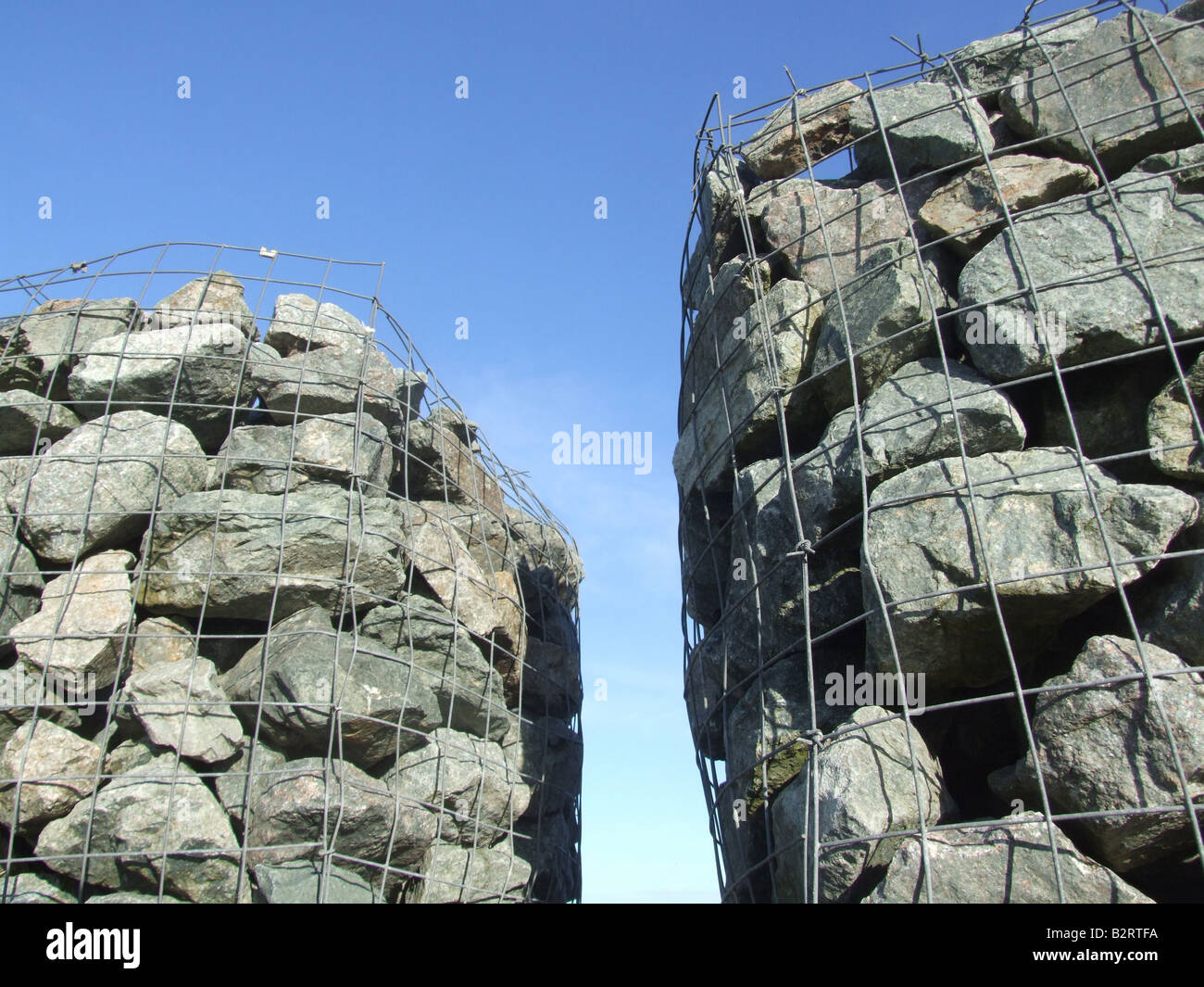 pile of rocks supported in a steel wire mesh Stock Photo - Alamy