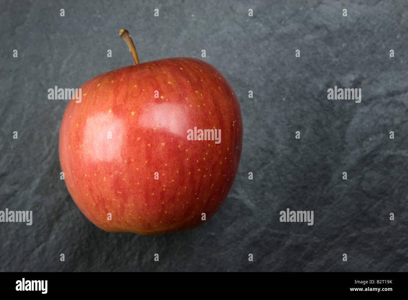 A red delicious apple on grey background Stock Photo - Alamy