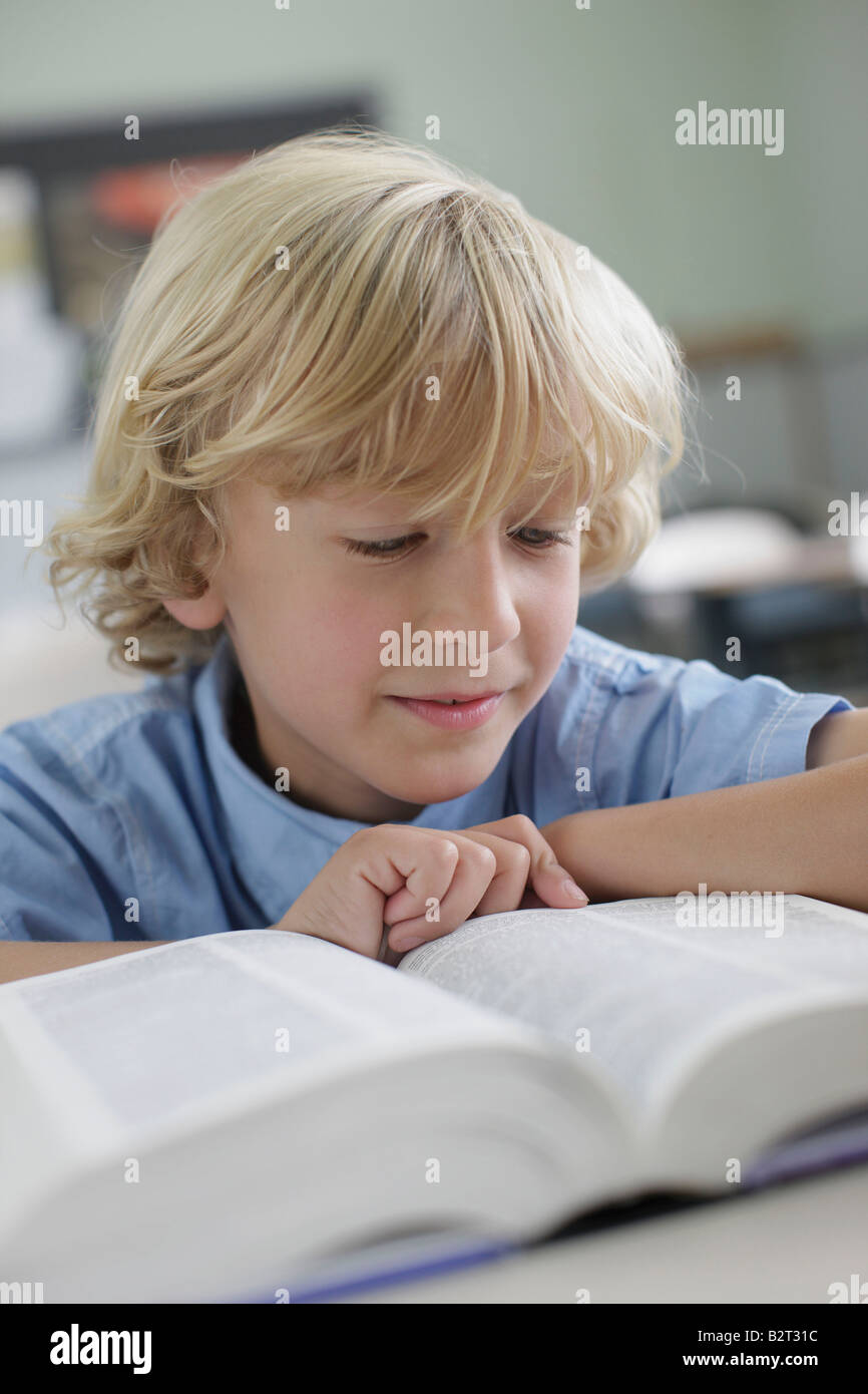 School boy reading book in class Stock Photo - Alamy