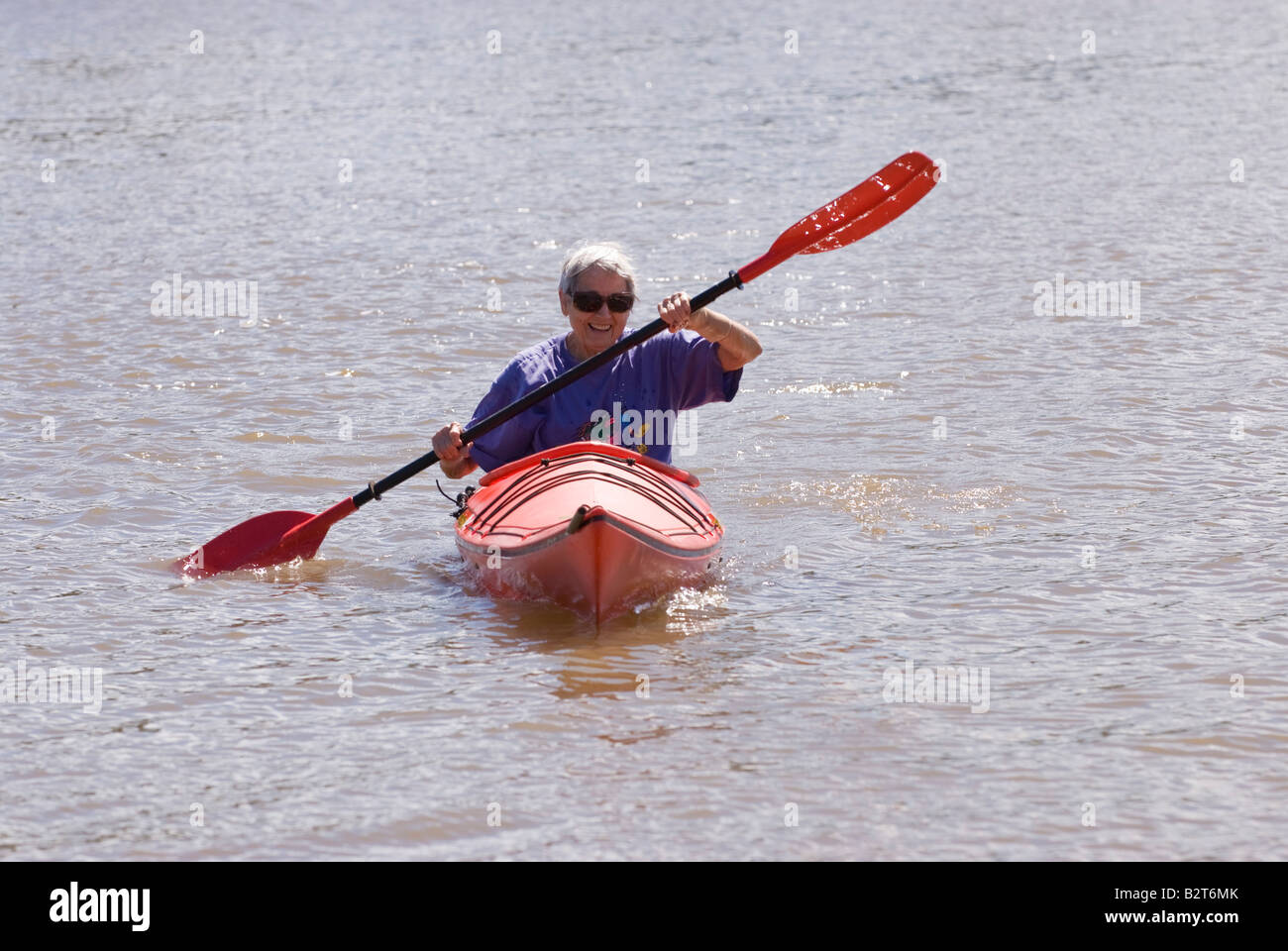 Mature woman paddling kayak Stock Photo - Alamy