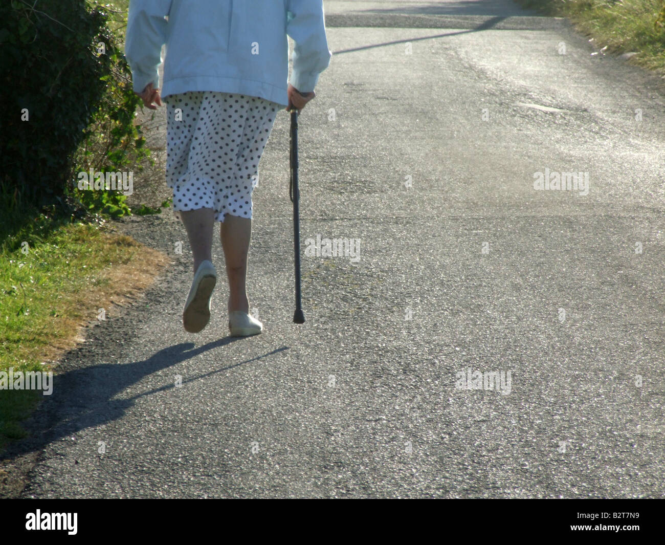 old lady with walking stick on rural country road Stock Photo - Alamy