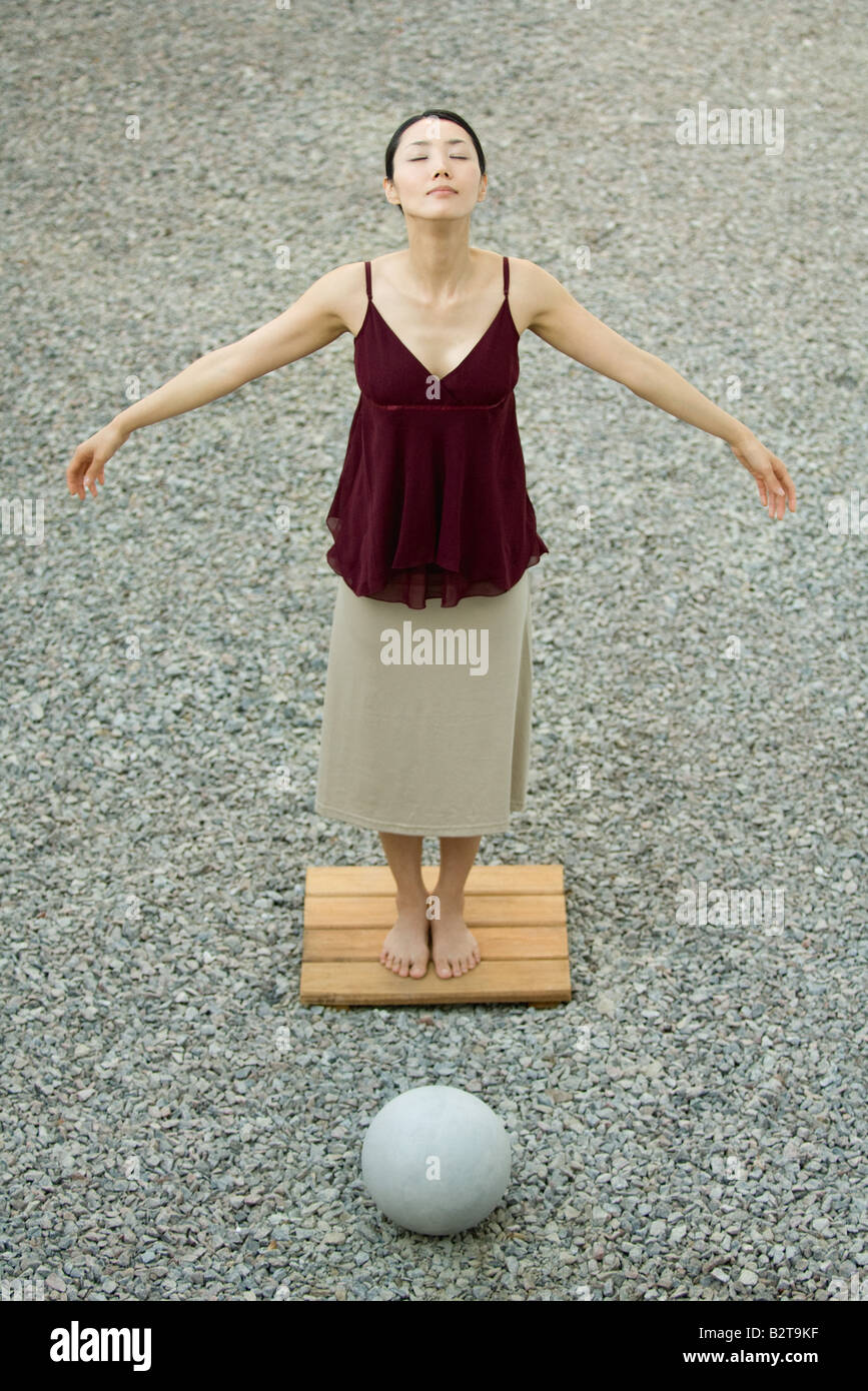 Woman standing with arms out and eyes closed, high angle view Stock ...