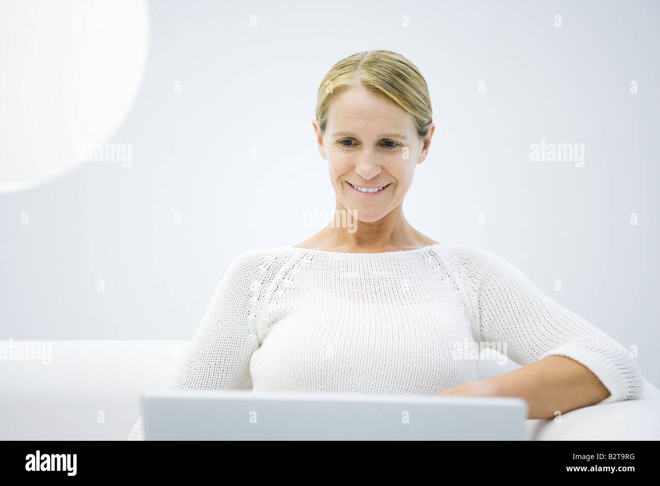 Woman using laptop, smiling Stock Photo - Alamy