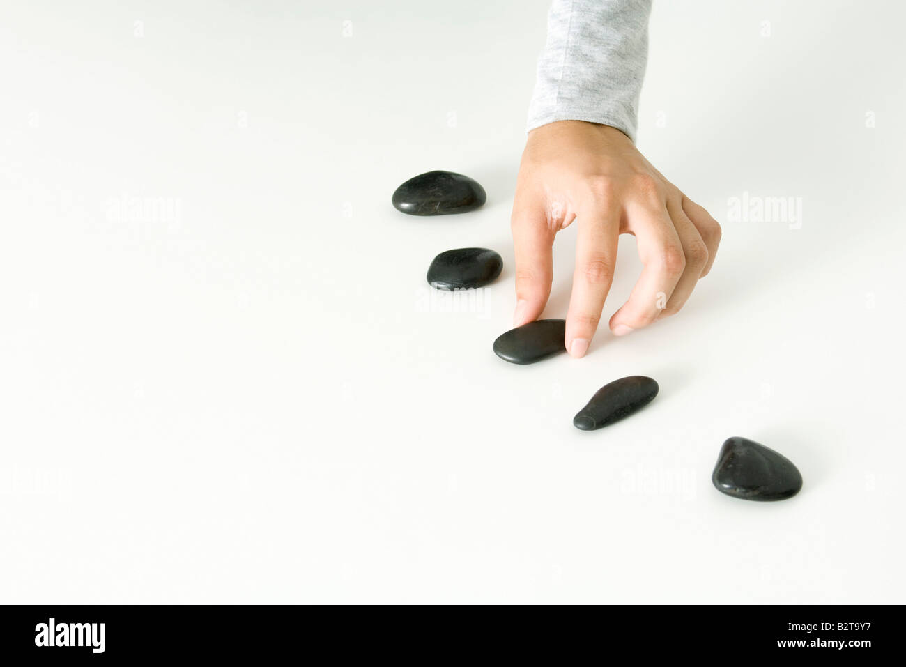 Hand arranging pebbles Stock Photo - Alamy
