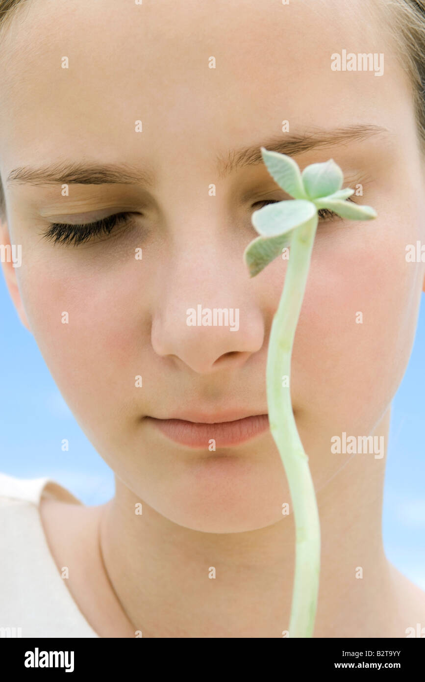 Girl with long stemmed succulent plant, eyes closed Stock Photo - Alamy