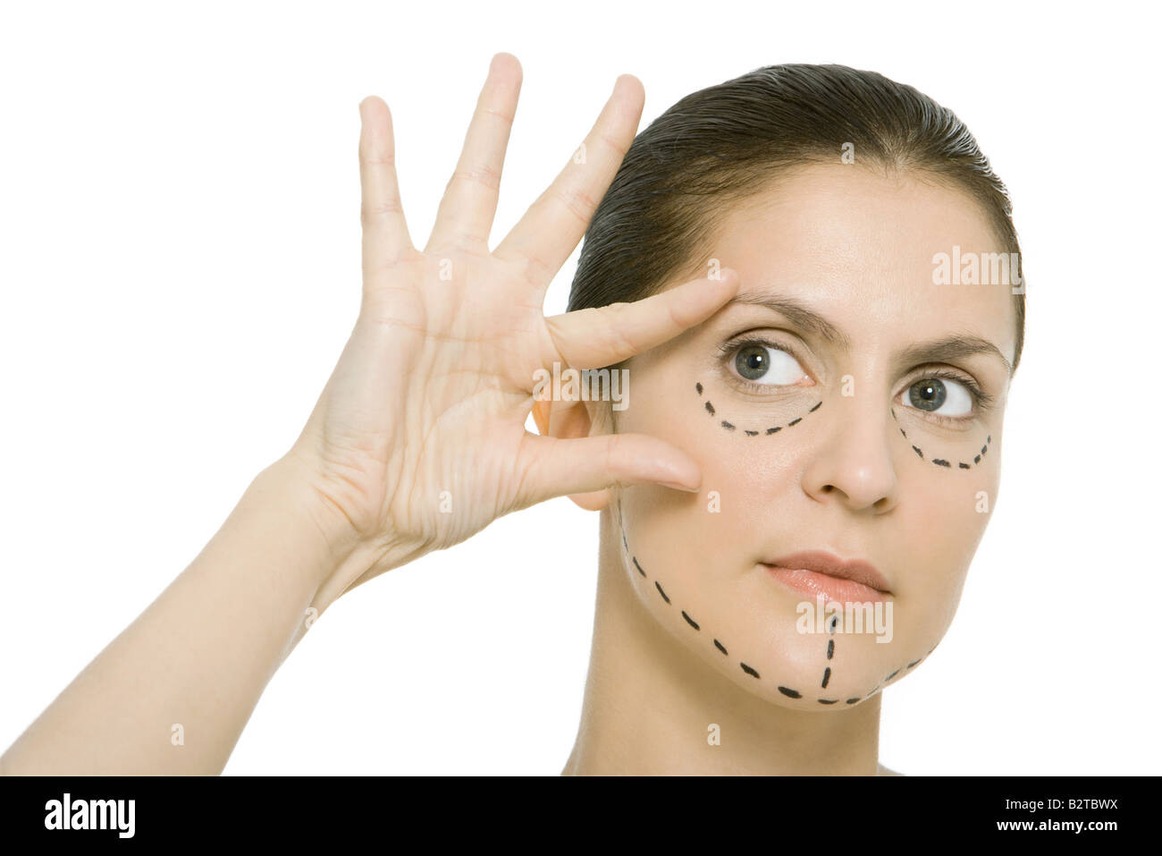 Woman with plastic surgery markings on face, touching face, looking ...