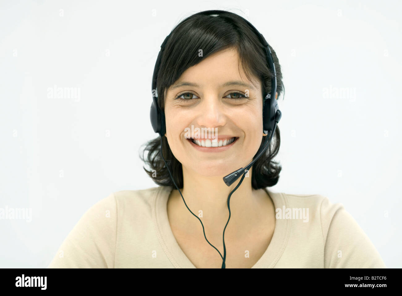 Woman wearing headset, smiling at camera, portrait Stock Photo - Alamy