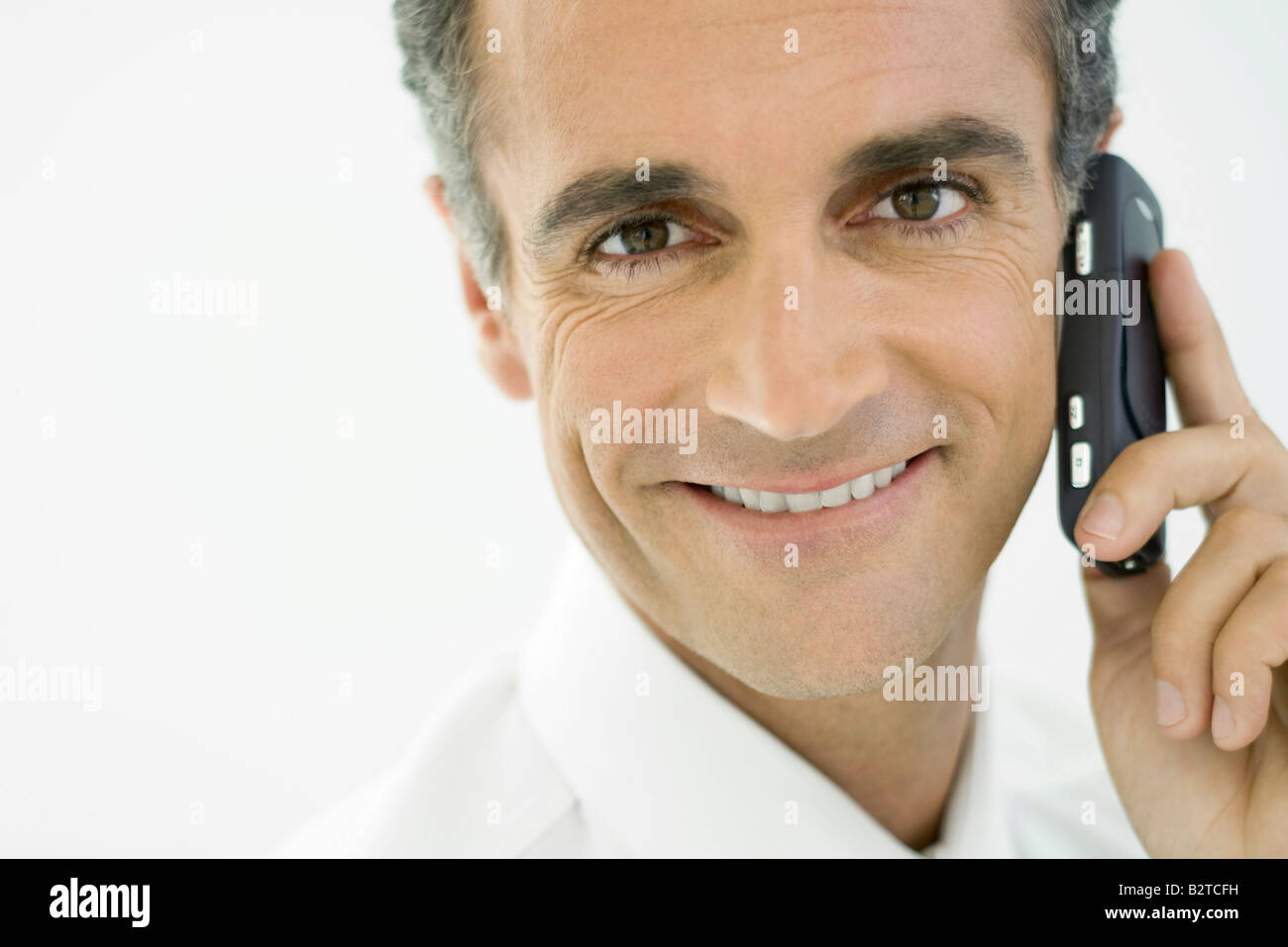 Man using cell phone, smiling at camera Stock Photo - Alamy