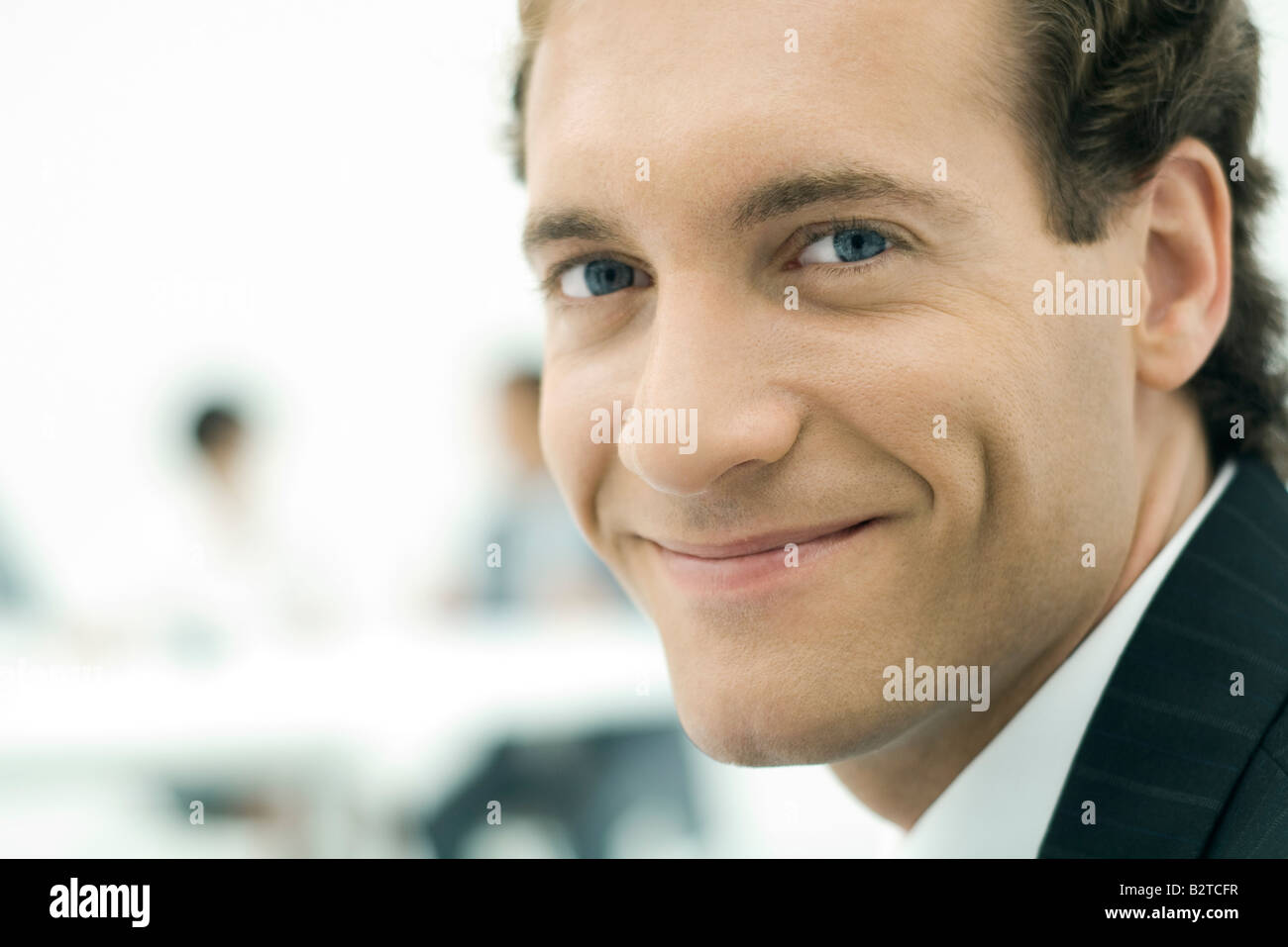 Man smiling over shoulder at camera, close-up Stock Photo - Alamy