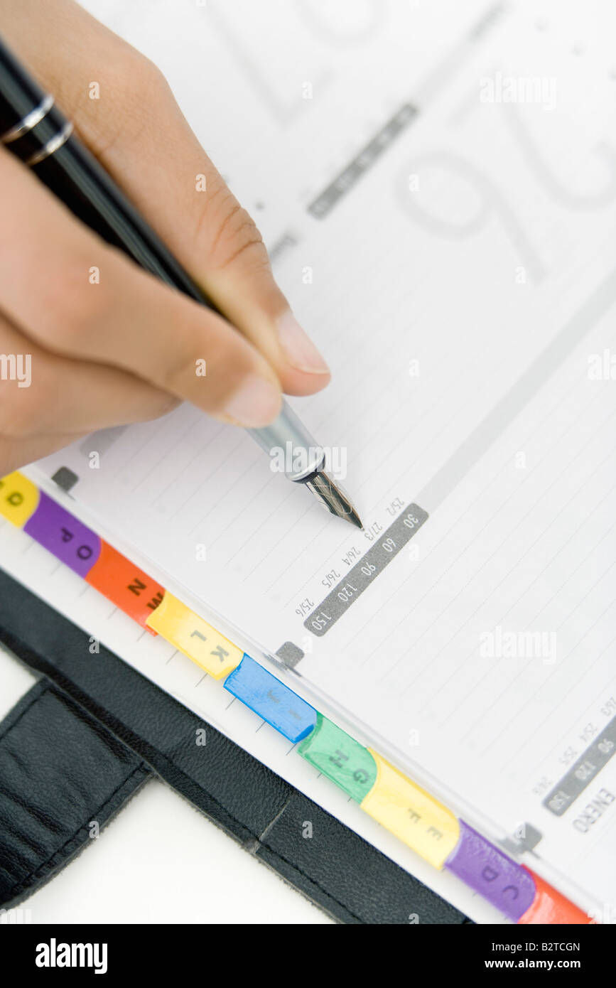 Person writing in agenda, cropped view of hand Stock Photo - Alamy