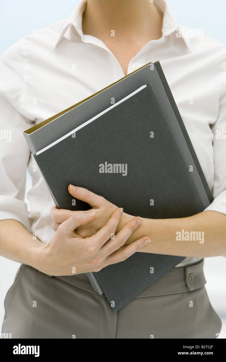 Female professional holding folders, cropped view Stock Photo - Alamy