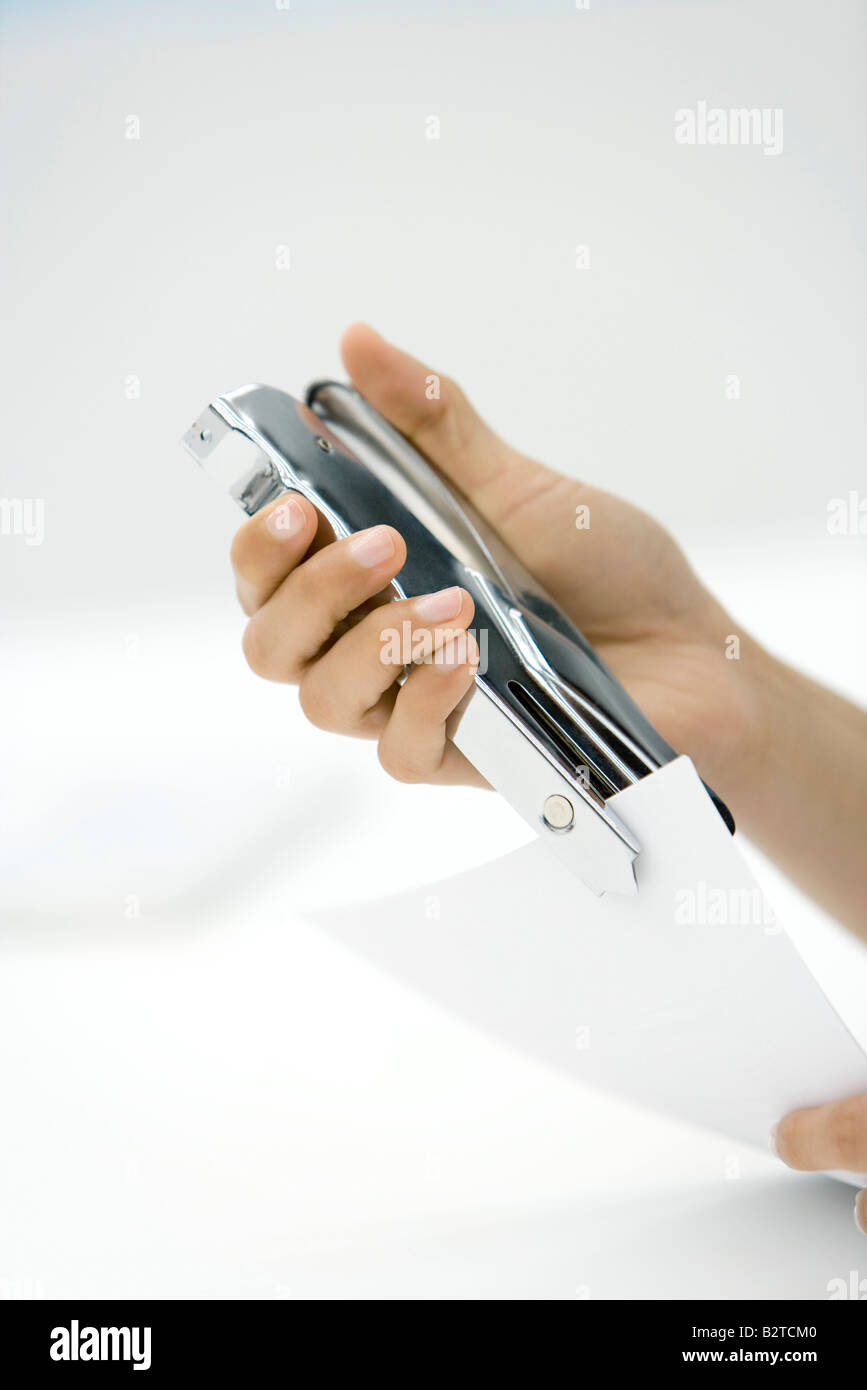 Person using stapler, cropped view of hands Stock Photo - Alamy