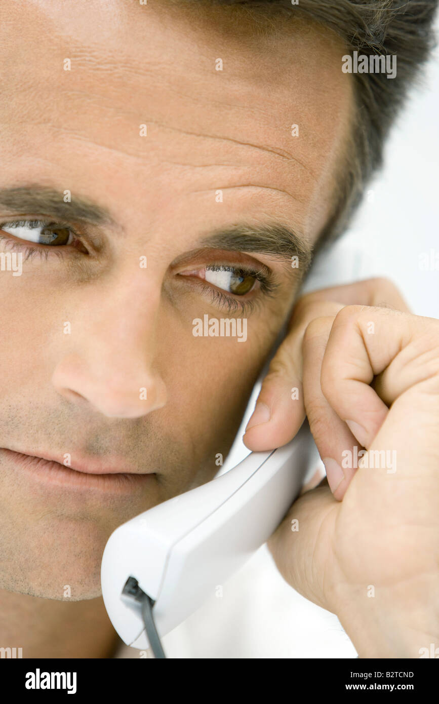 Man using landline phone, looking away, cropped Stock Photo - Alamy