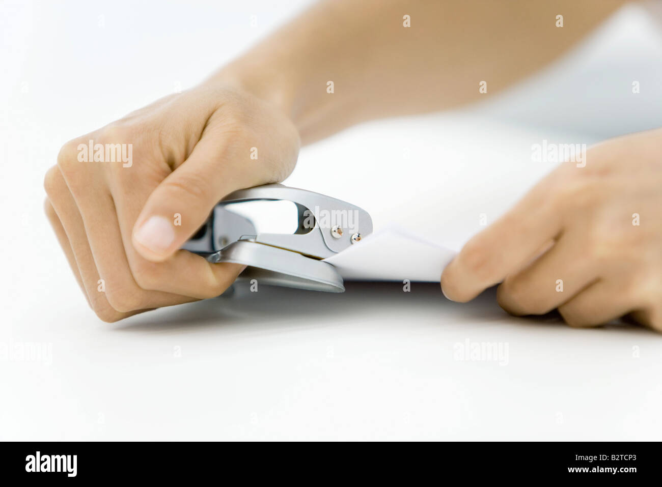 Person using hole puncher on document Stock Photo - Alamy