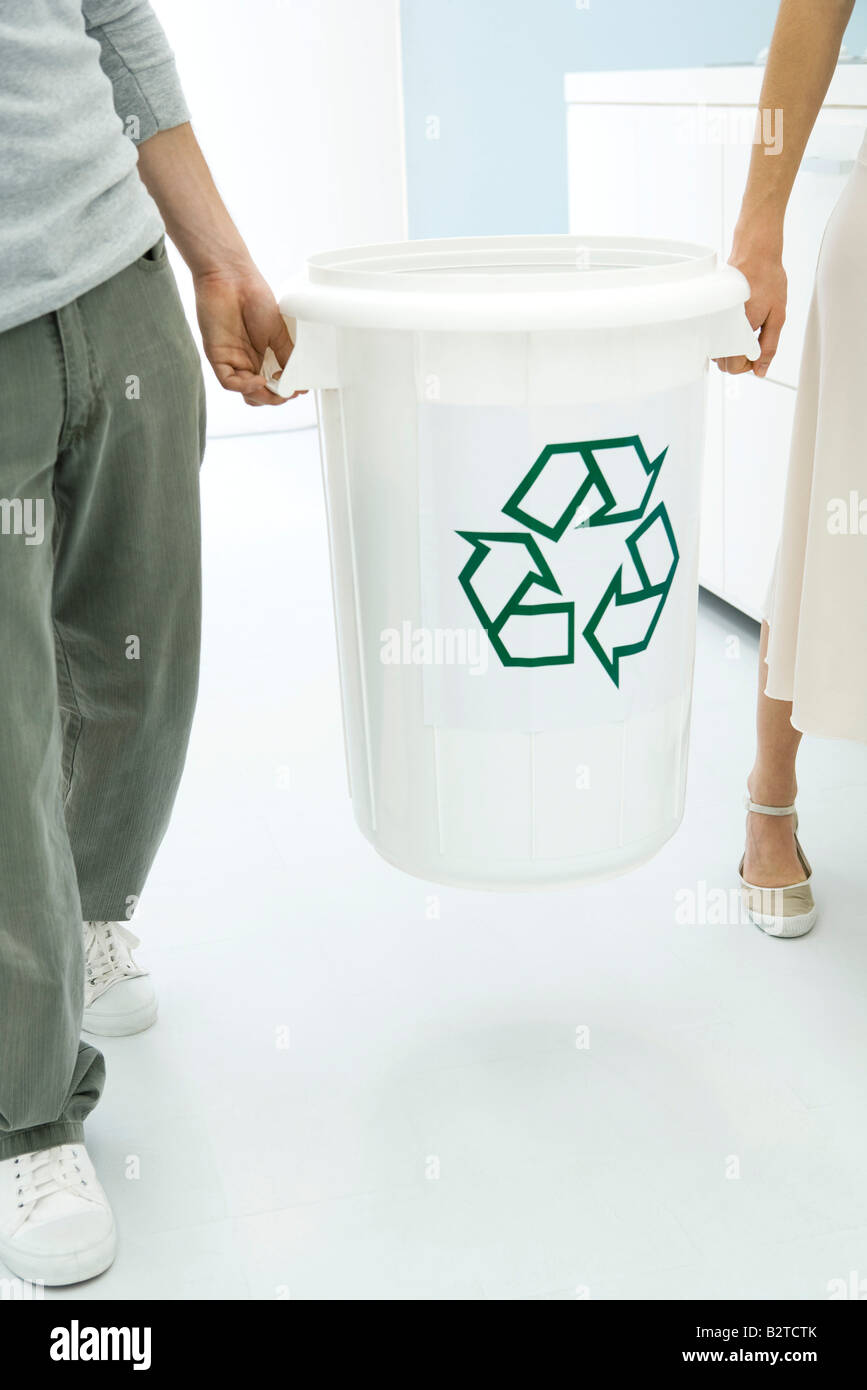 Two people carrying recycling bin together, cropped view Stock Photo ...