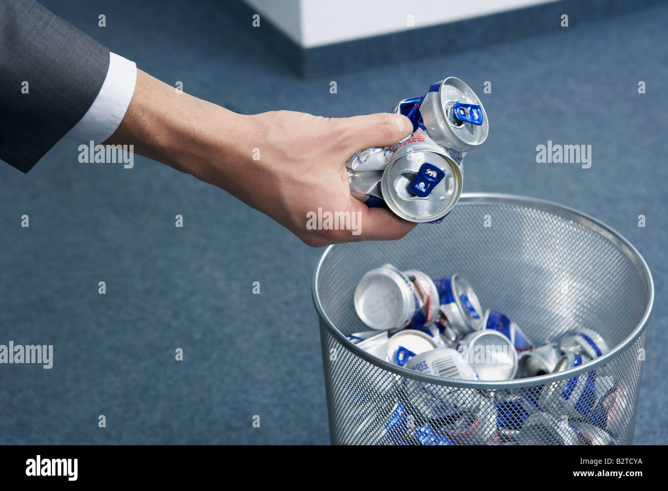 Cans being placed into bin Stock Photo - Alamy