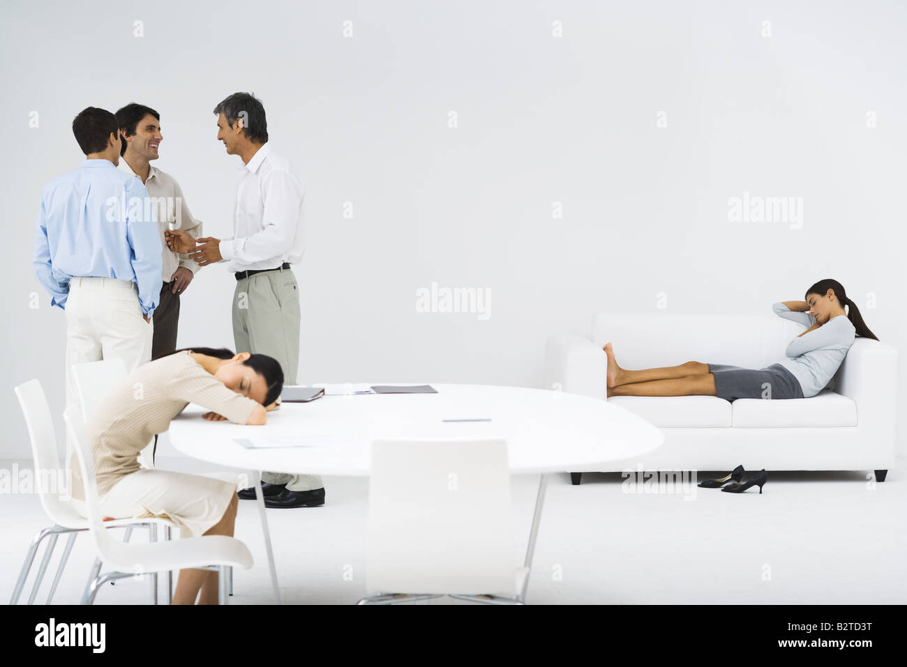 Women napping, one at table, one on couch, men talking in group in the ...