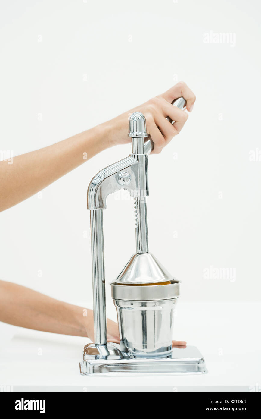 Hand using chrome juicer, cropped view Stock Photo - Alamy