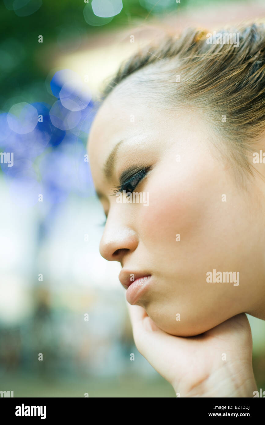 Young woman with hand under chin, profile Stock Photo - Alamy