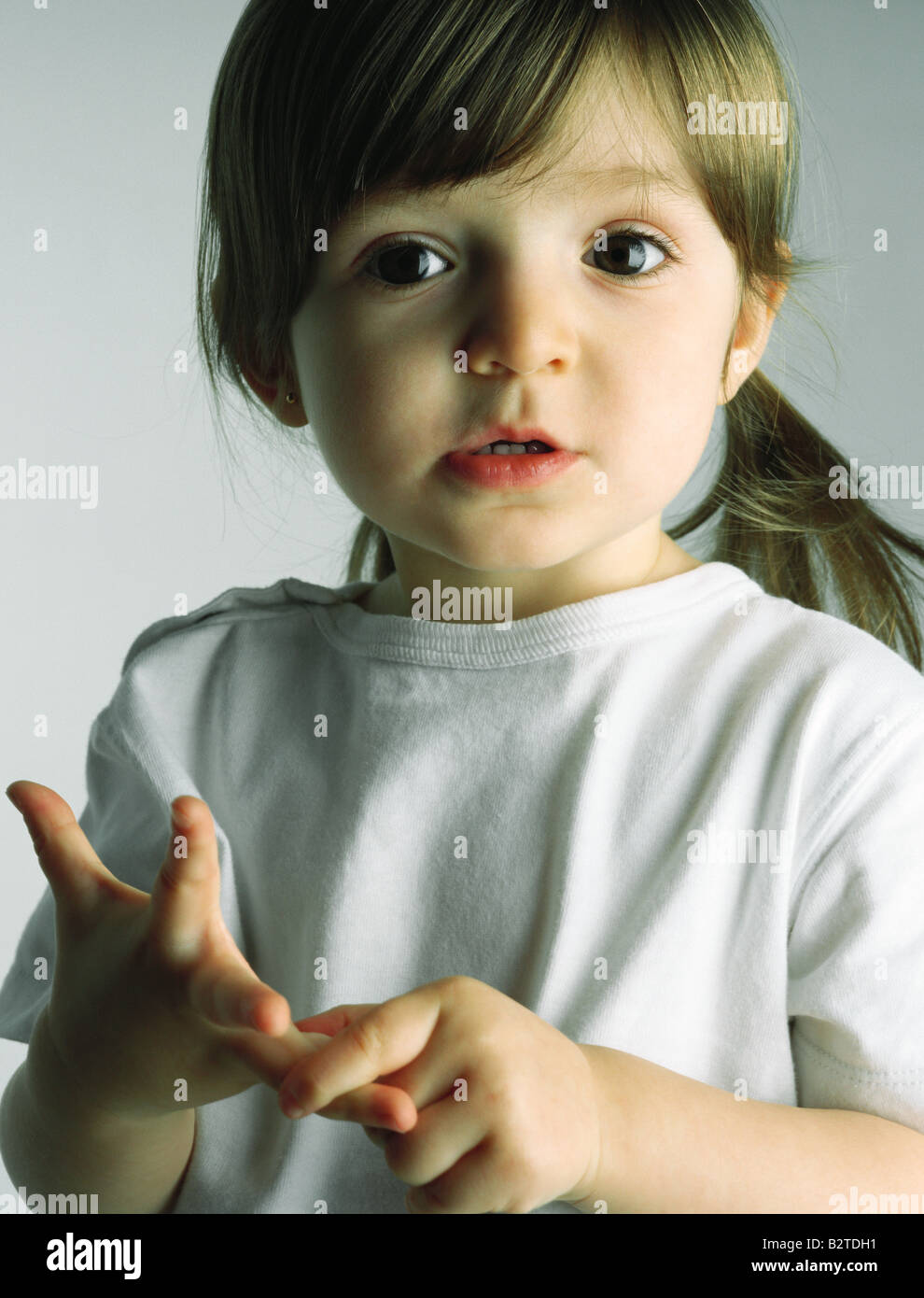 Little girl counting with her fingers, looking at camera, portrait ...