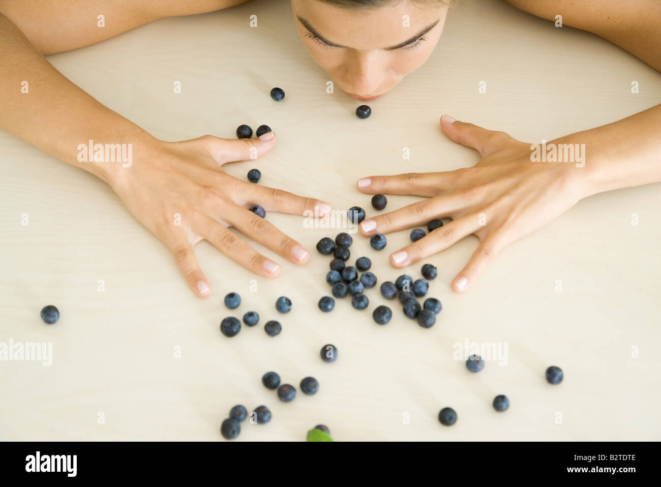Woman leaning over scattered blueberries, cropped view Stock Photo - Alamy
