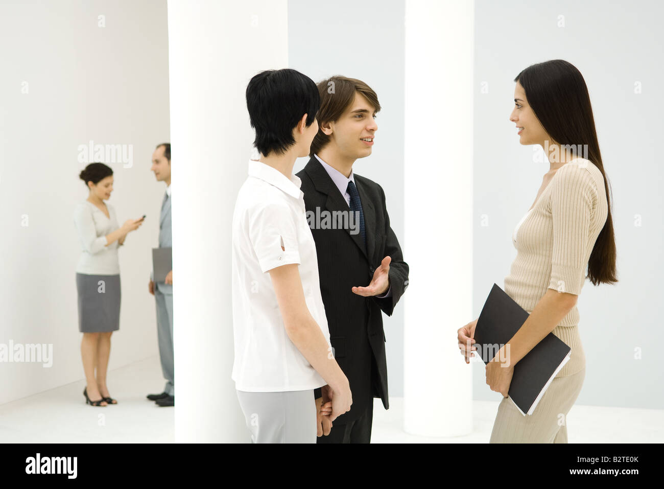 Young businessman introducing two business women to each other, smiling ...