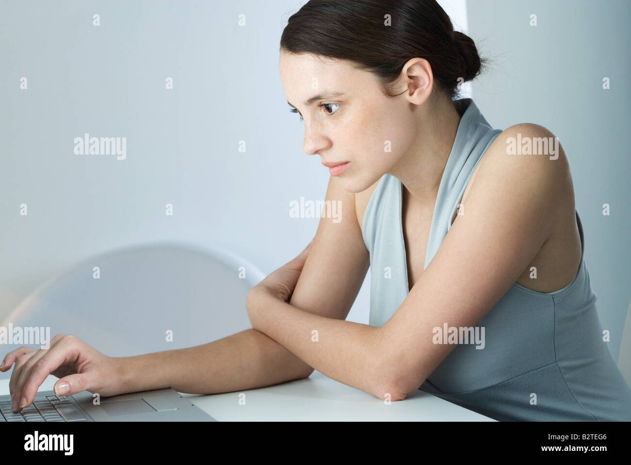Woman using laptop computer, side view Stock Photo - Alamy