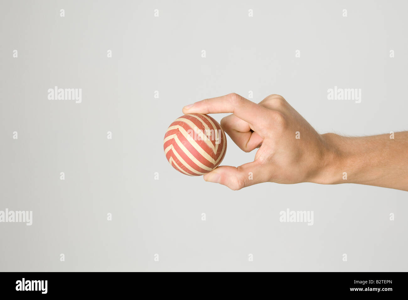 Hand holding striped ball Stock Photo - Alamy