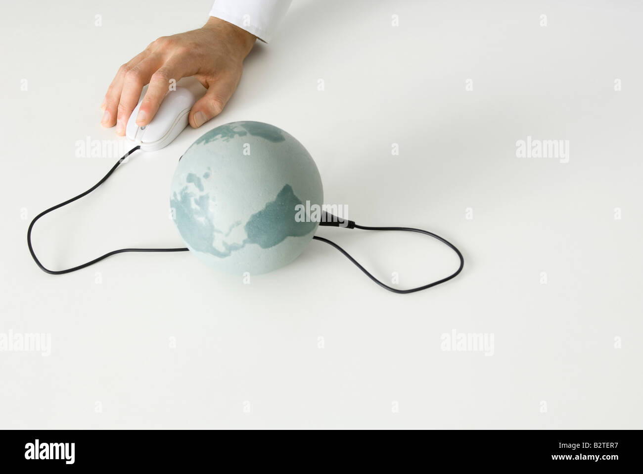 Hand using computer mouse connected to globe Stock Photo - Alamy