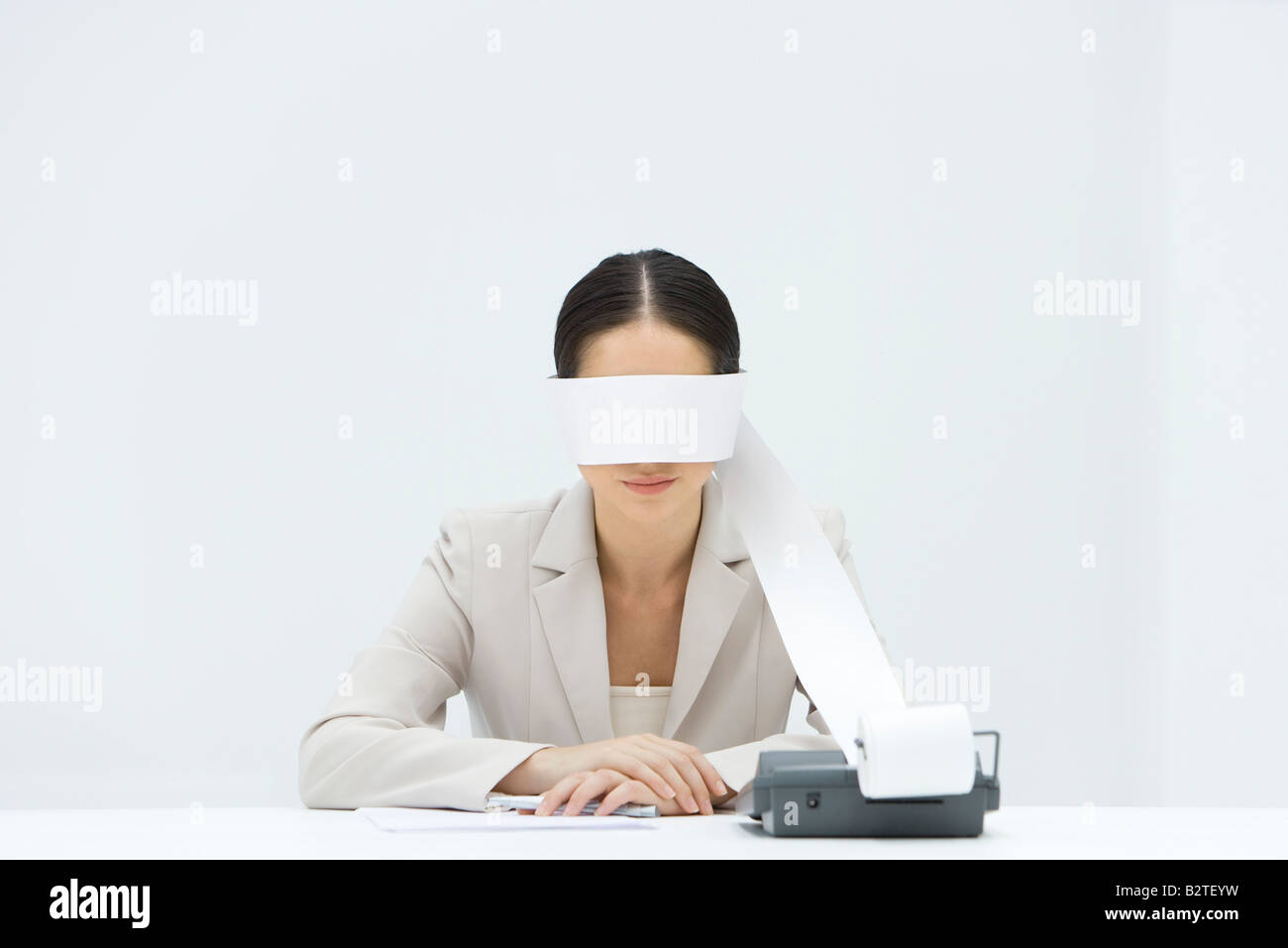 Woman sitting at desk, tape from an adding machine wrapped around her ...