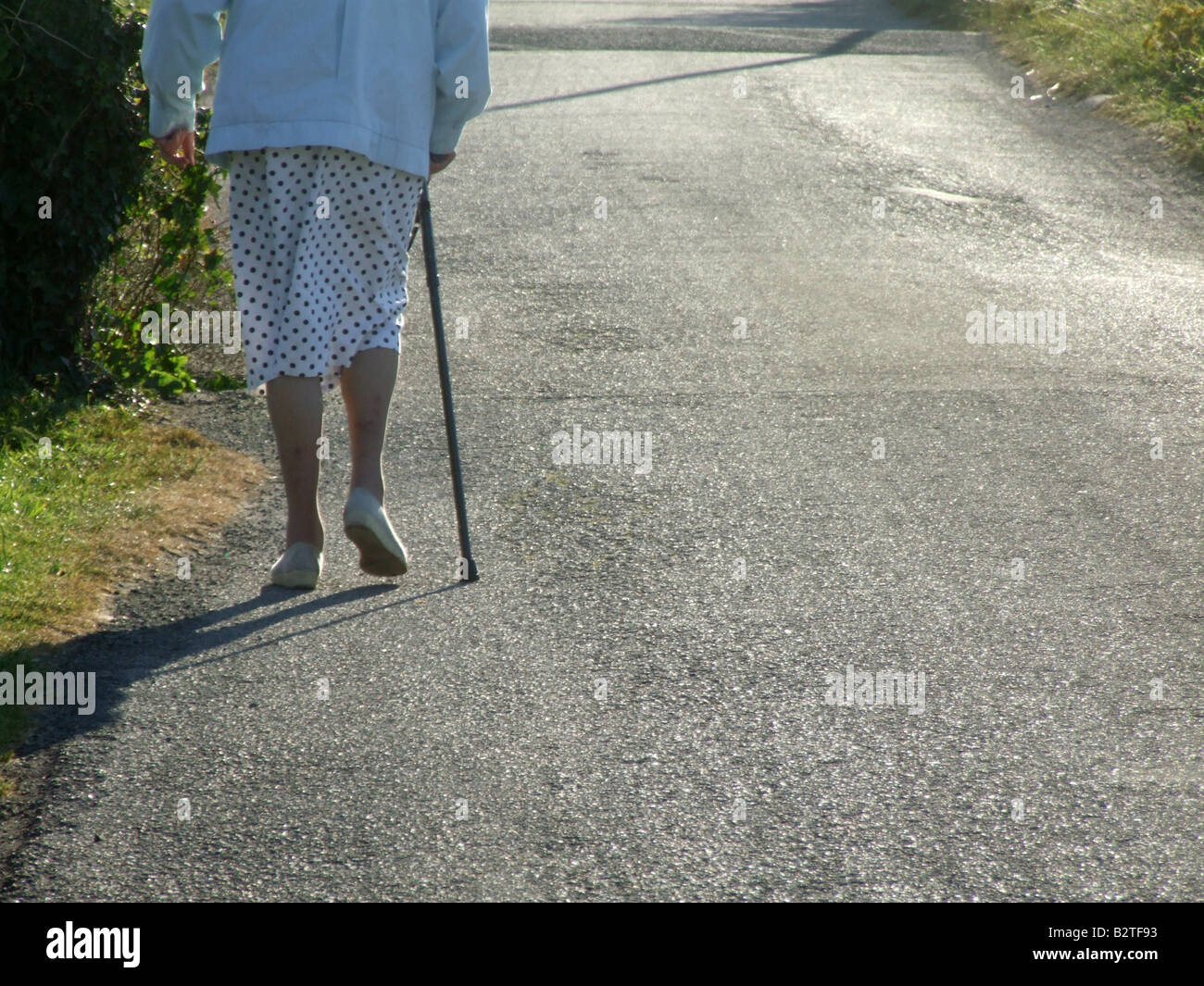 old lady with walking stick on rural country road Stock Photo - Alamy
