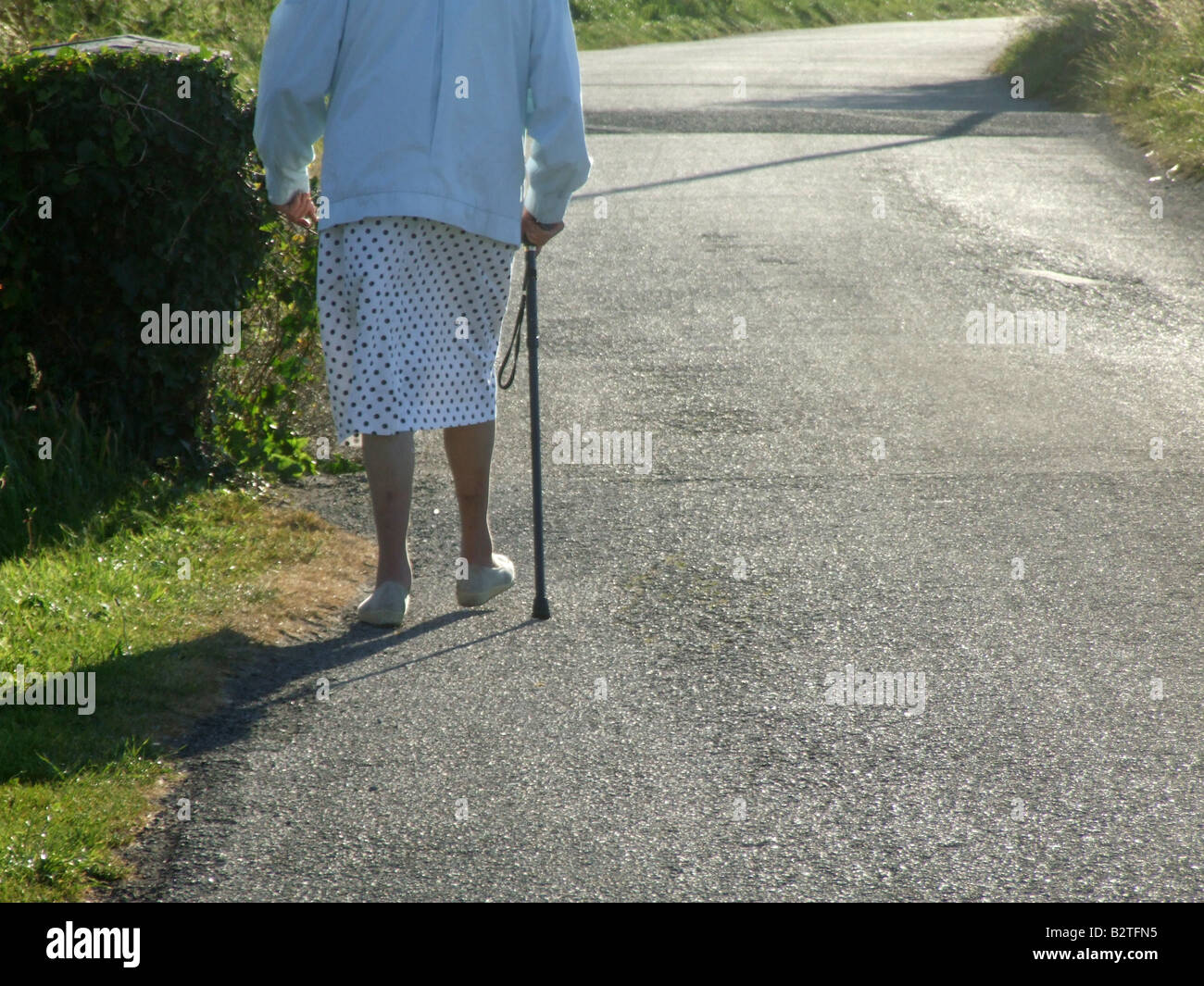 old lady with walking stick on rural country road Stock Photo - Alamy