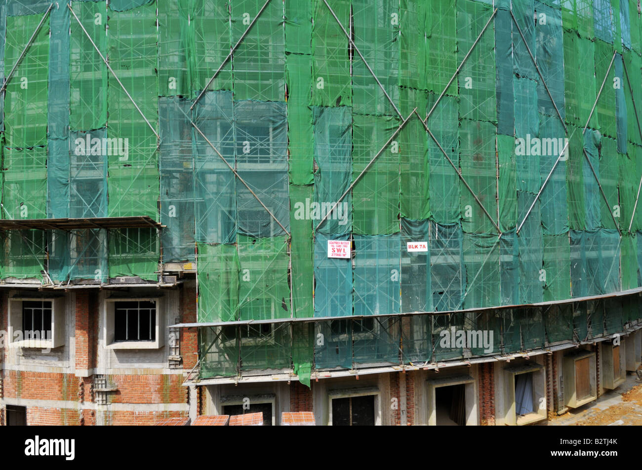 A green safety covering wrapped around a building or construction site ...
