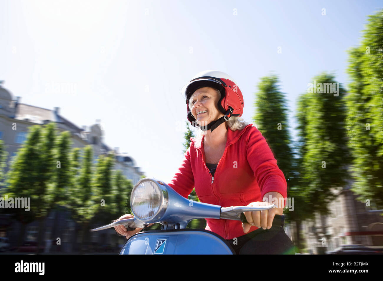 Woman driving a scooter Stock Photo - Alamy