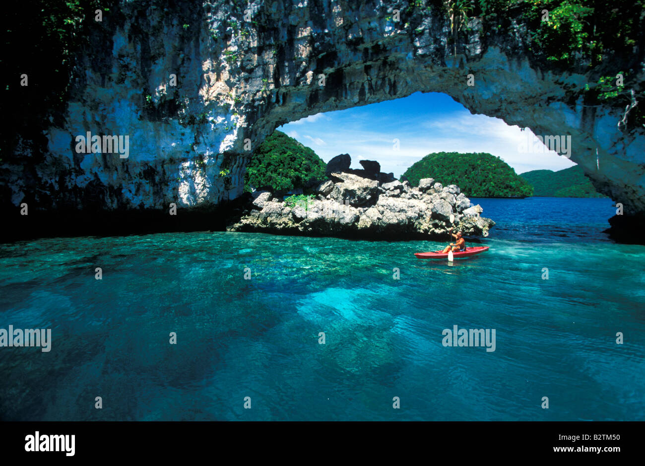 Ocean kayak through rock arch island in background Palau Micronesia ...