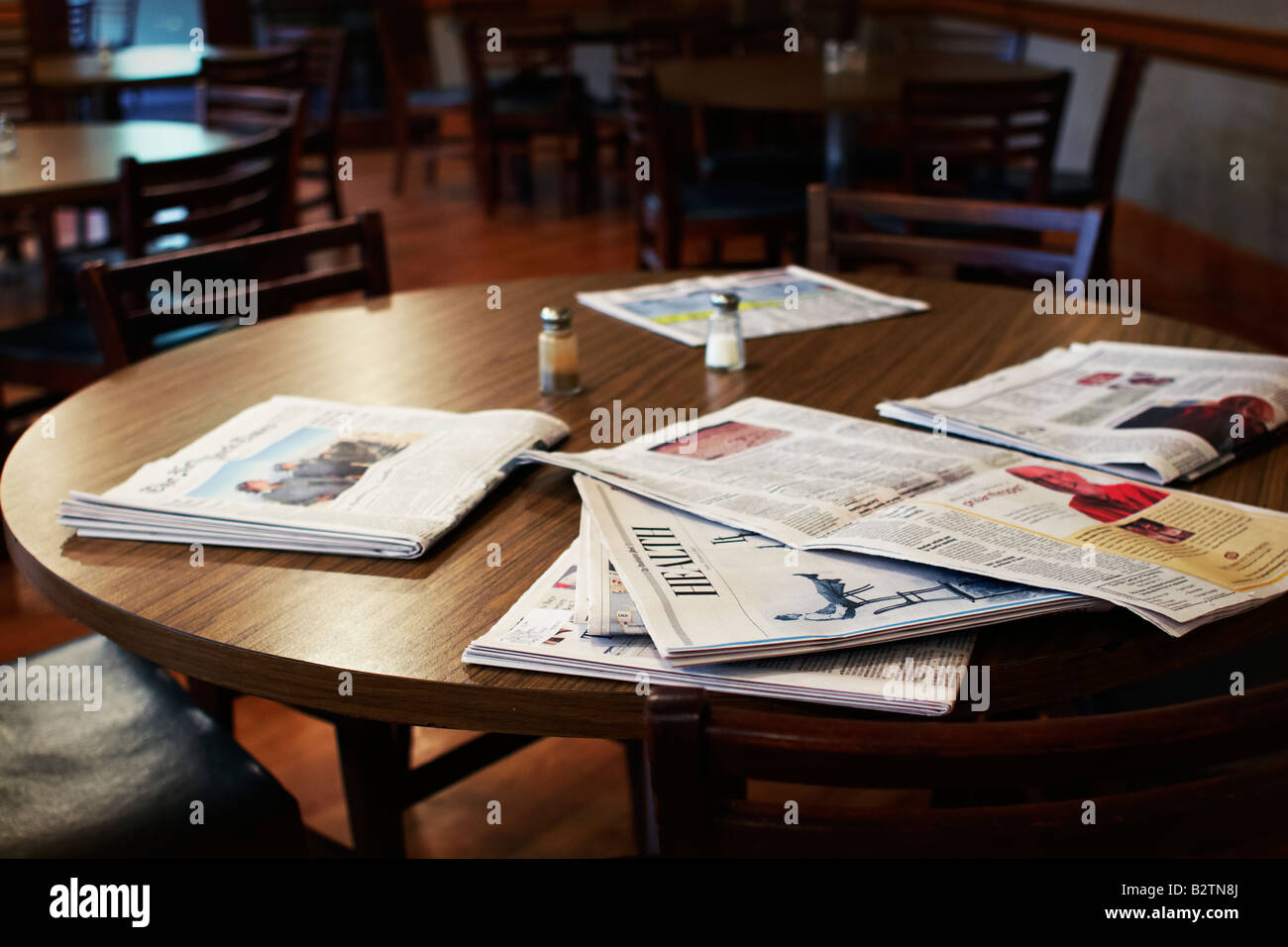 A table in a dining hall covered with morning papers Stock Photo - Alamy