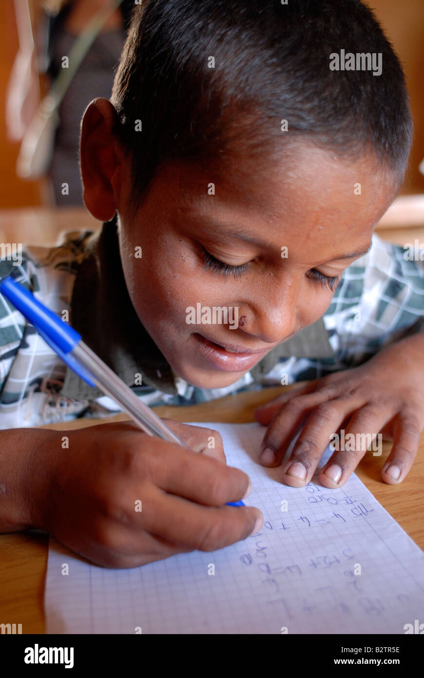 Young boy writing at school Albania Stock Photo - Alamy
