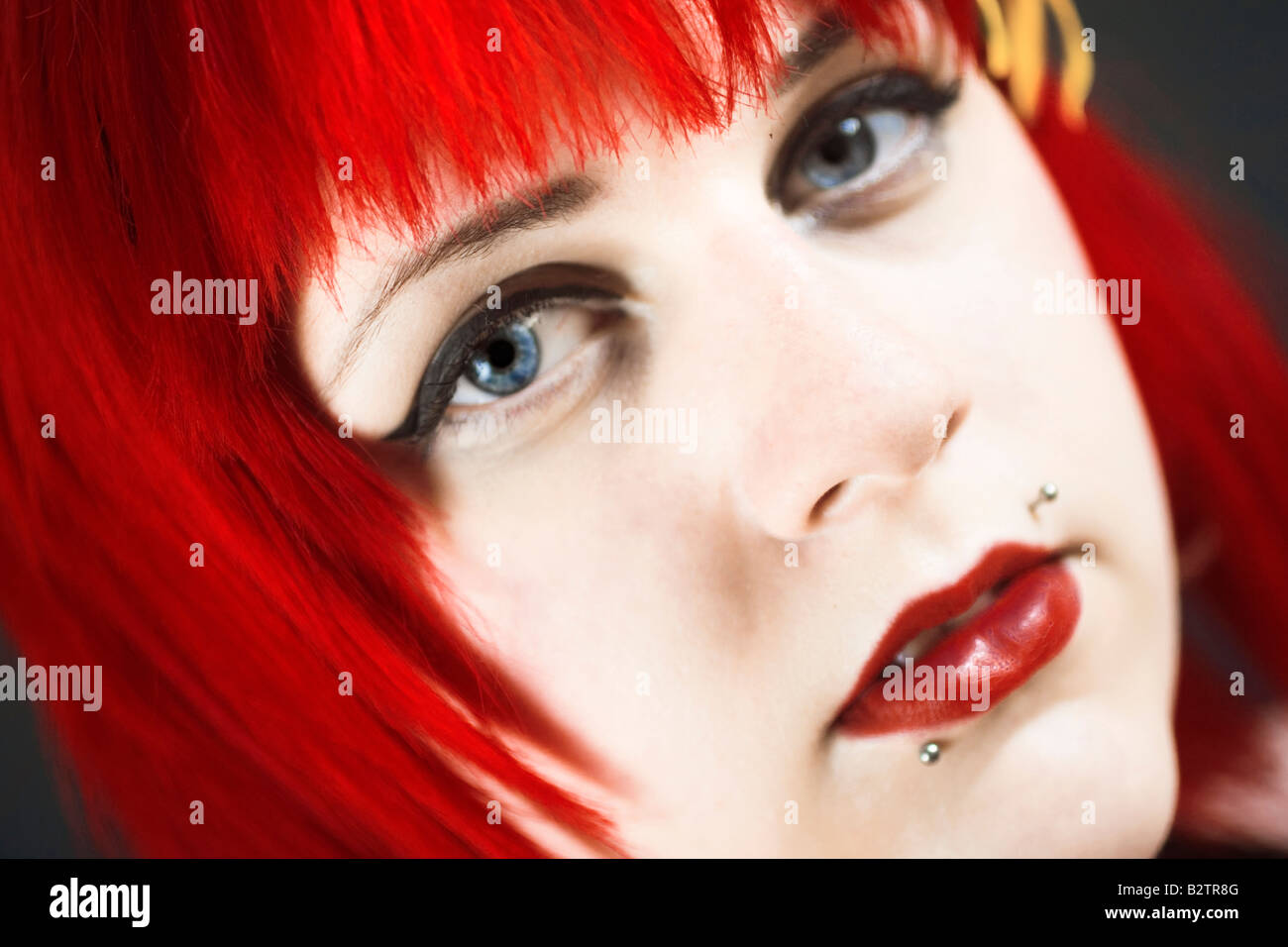 Headshot portrait of a young goth woman with bright red hair Stock ...