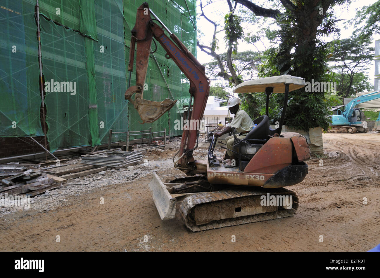 Mini digger at Singapore construction site Stock Photo - Alamy
