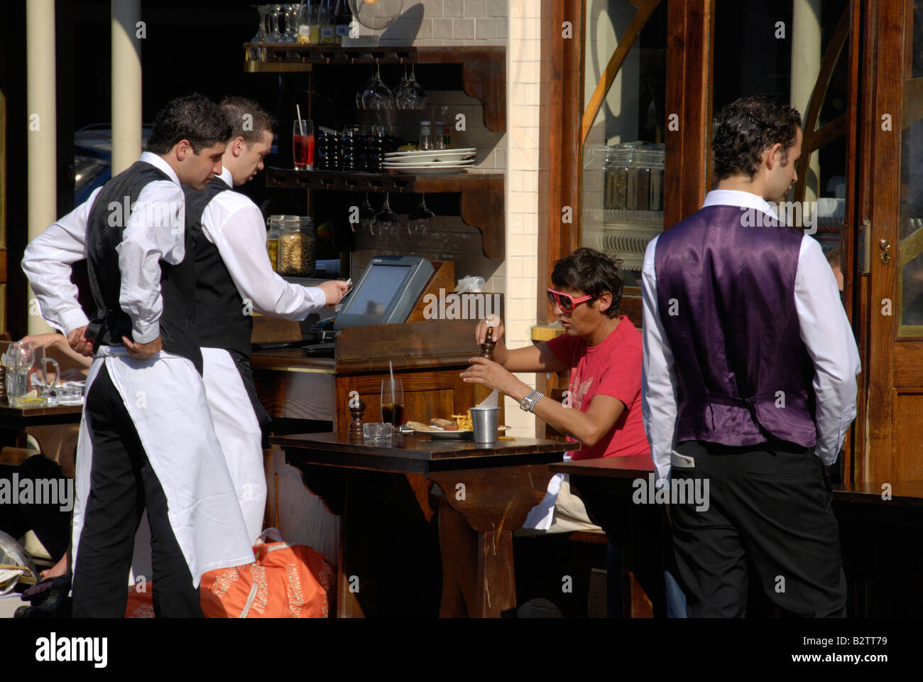 Waiters and customers outside bar restaurant in Summer, Old Compton ...