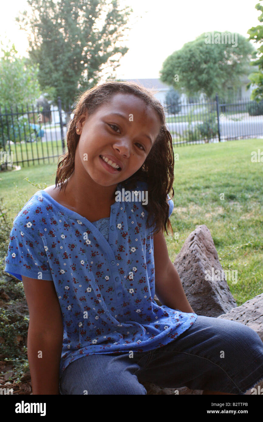 African american girl sitting outside Stock Photo - Alamy