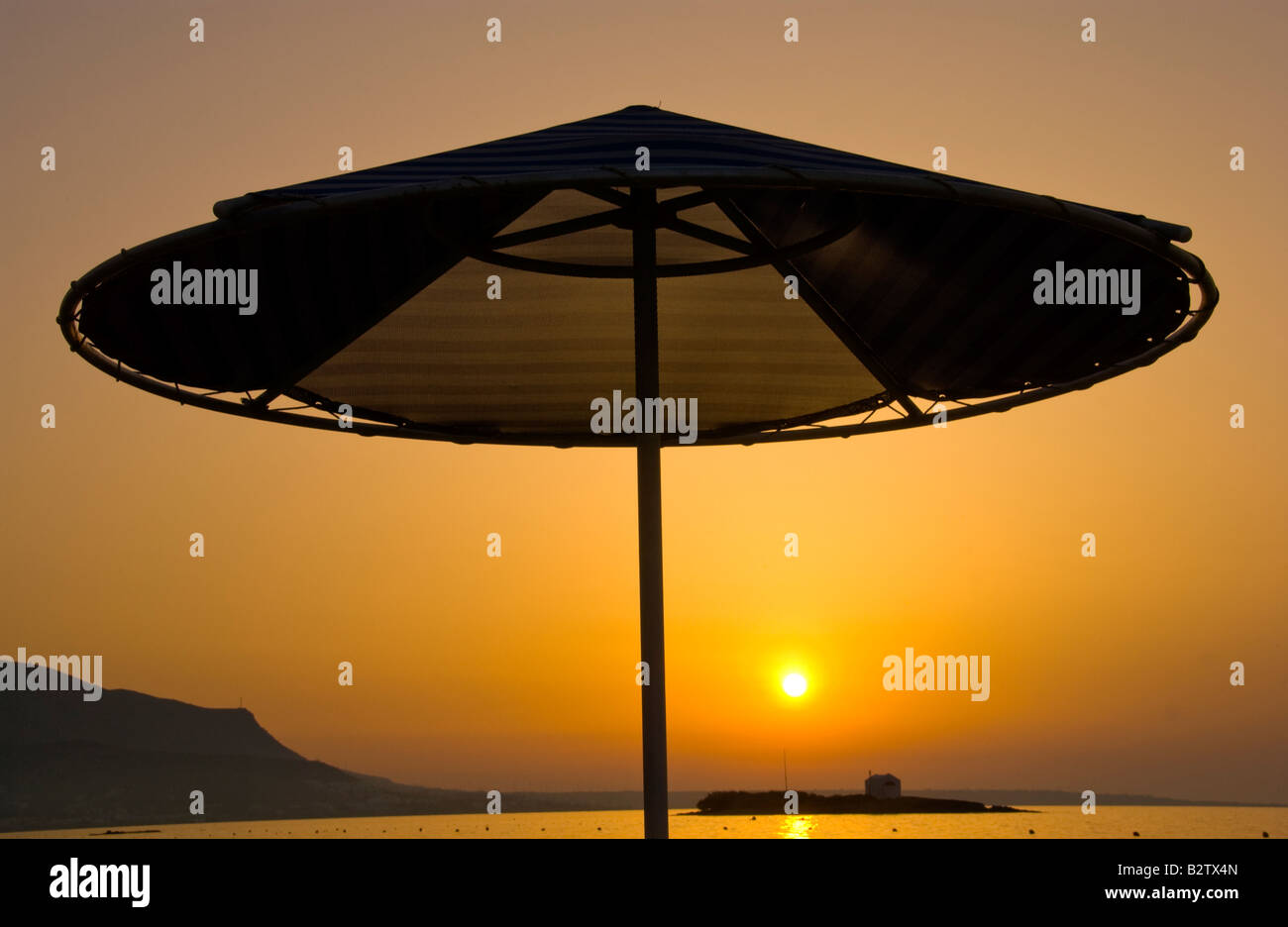 Crete beach Sunset over Malia beach umbrella on the Greek Mediterranean ...