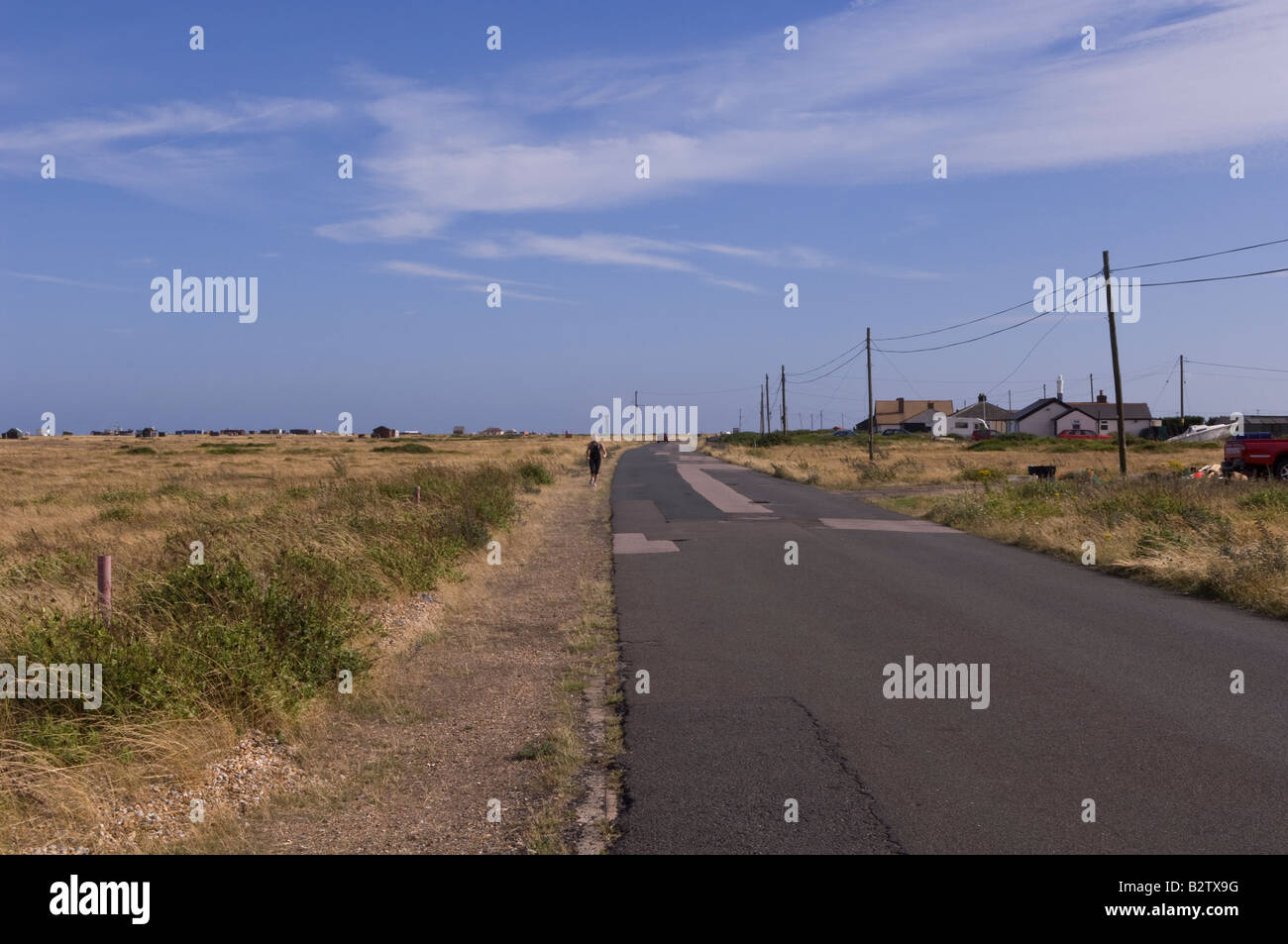 A lone runner jogs along the isolated coastal road at Dungeness in Kent ...