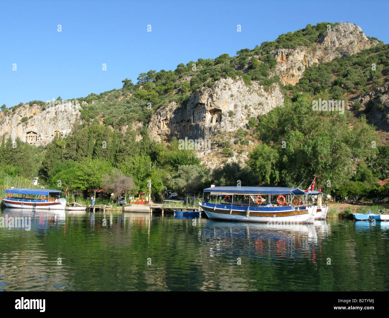 Toursit boat passing Kings tombs Kaunos Dalyan Turkey Stock Photo - Alamy