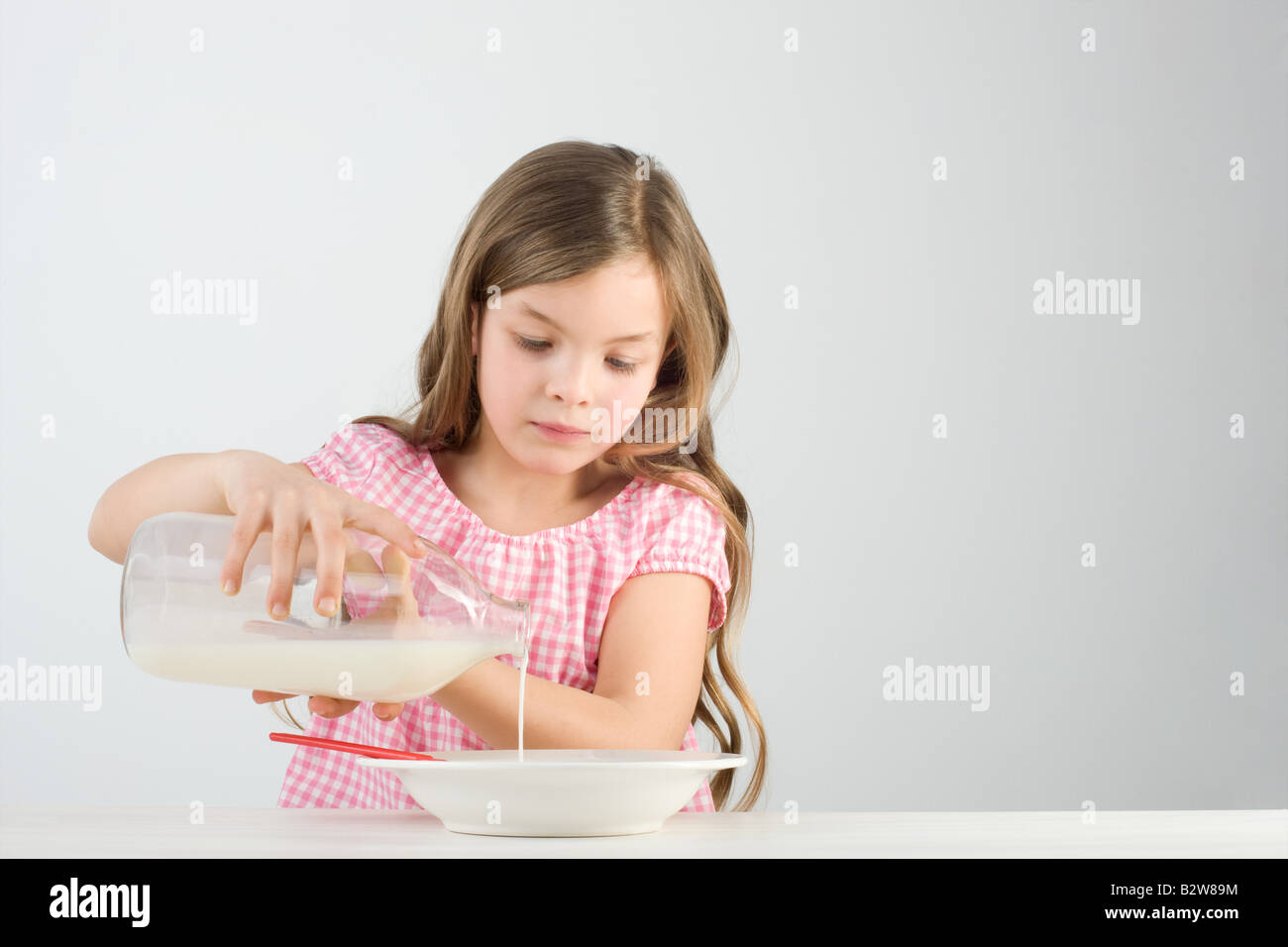 Girl pouring milk Stock Photo - Alamy