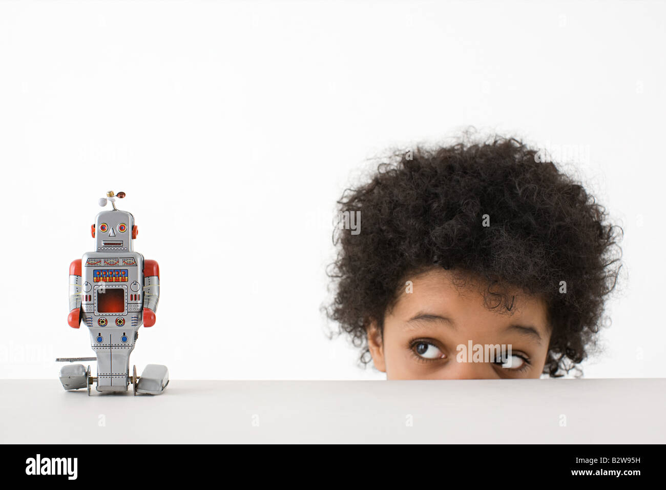 Boy looking at robot Stock Photo - Alamy