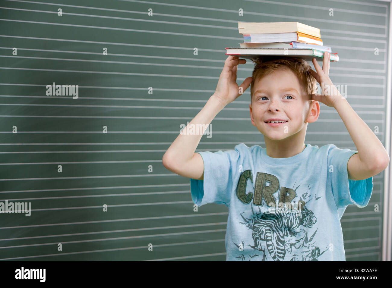 Boy with books on his head Stock Photo - Alamy