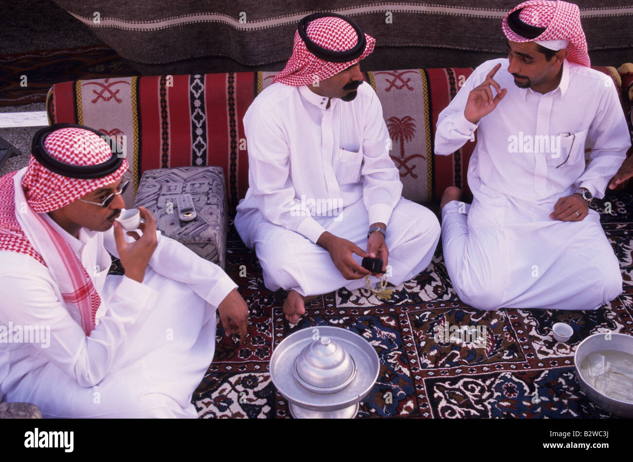Asia, Middle Est, Saudi Arabia, drinking a tea during a conversation in ...